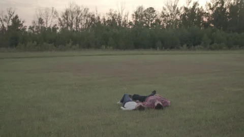 Young Girl Laying in a Field with Her Fa... | Stock Video | Pond5