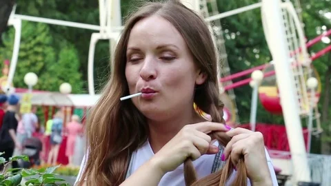 A young girl with long hair lishes lolli... | Stock Video | Pond5