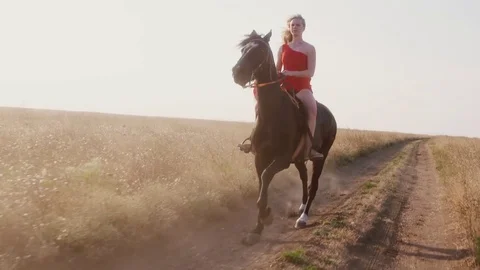 Young girl in long scarlet red dress rid... | Stock Video | Pond5