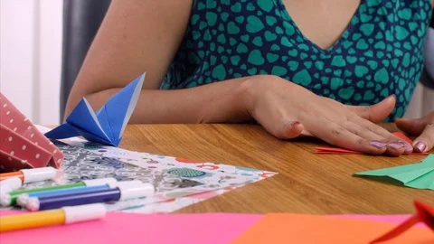 Young girl making paper toy with origami... | Stock Video | Pond5