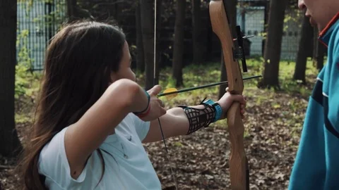Young girl shooting arrow with bow at ci... | Stock Video | Pond5