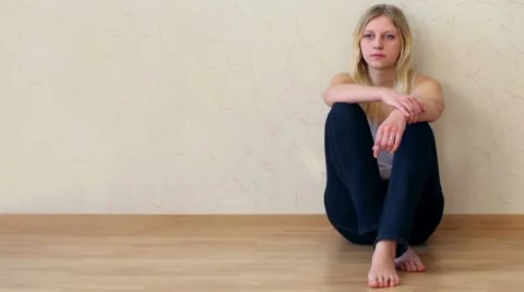 Young girl sits on floor with back press... | Stock Video | Pond5