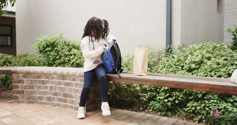Young girl sitting on bench, opening bac... | Stock Video | Pond5