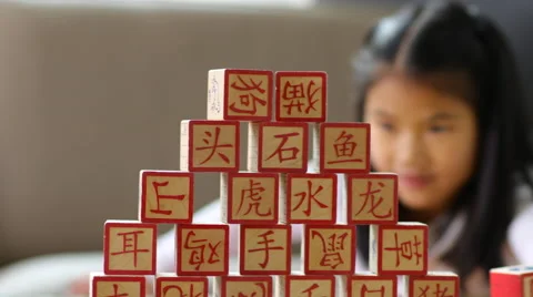 Young girl stacking Chinese blocks | Stock Video | Pond5