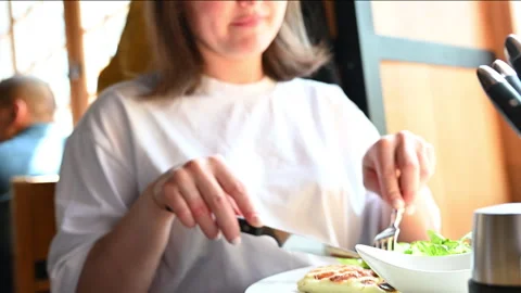 A young girl tastes delicious food in a ... | Stock Video | Pond5