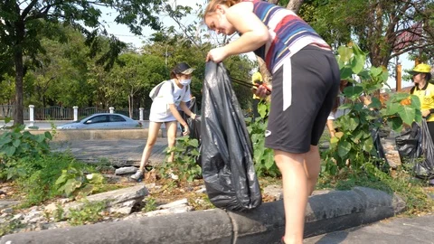 Young girls picking up trash from street... | Stock Video | Pond5