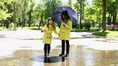 young girls running throught the puddles... | Stock Video | Pond5