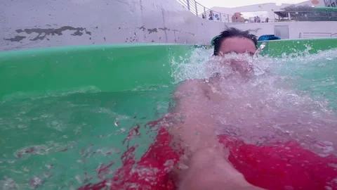 Young guy rolls out of a pipe in a water... | Stock Video | Pond5