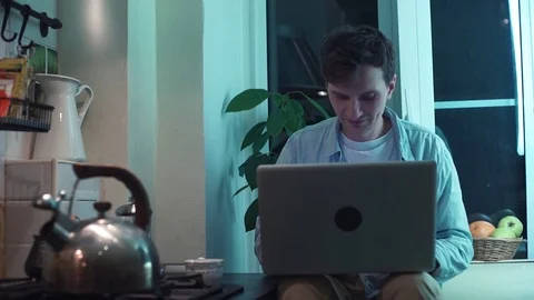 Young guy typing on computer sitting at ... | Stock Video | Pond5