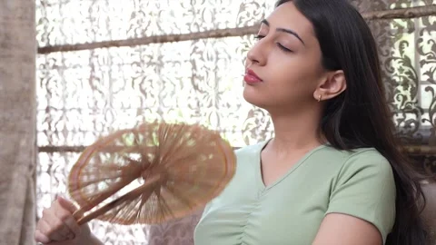 Young Indian girl using hand waver fan s... | Stock Video | Pond5