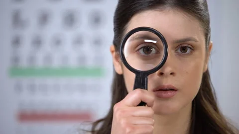 Young lady looking through lens to cam, ... | Stock Video | Pond5