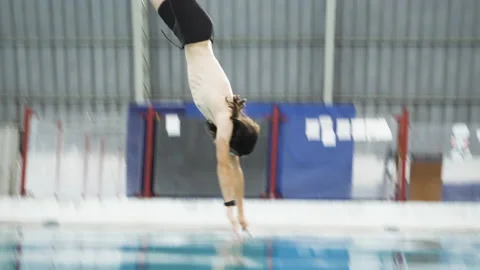 young male jumps to pool and dives | Stock Video | Pond5