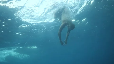 Young male swimmer dives into the deep b... | Stock Video | Pond5