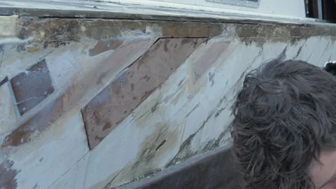A young man applying epoxy filler to a w... | Stock Video | Pond5