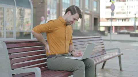 Young Man with Back Pain Using Laptop wh... | Stock Video | Pond5