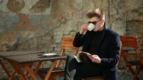 Young Man in a black Coat sitting alone ... | Stock Video | Pond5