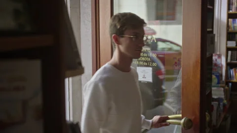 Young man enters the book store through ... | Stock Video | Pond5