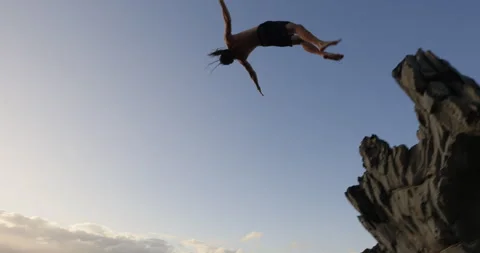 Young man extreme cliff jumping backflip... | Stock Video | Pond5