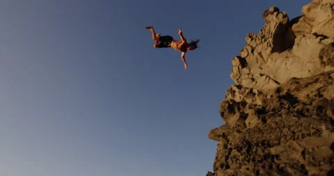 Young man extreme cliff jumping backflip... | Stock Video | Pond5