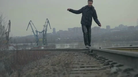 Young man goes to rail against backdrop ... | Stock Video | Pond5