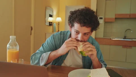Young man has snack while sitting in the... | Stock Video | Pond5
