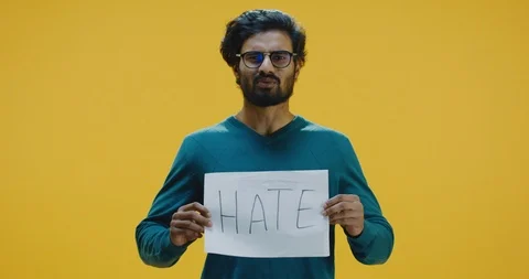 Young man holding hate sign and talking | Stock Video | Pond5