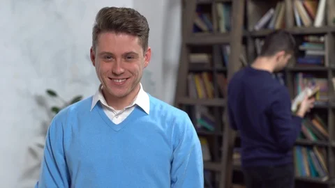 Young man in library looking camera smil... | Stock Video | Pond5