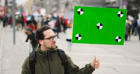 Young man is looking at poster with gree... | Stock Video | Pond5