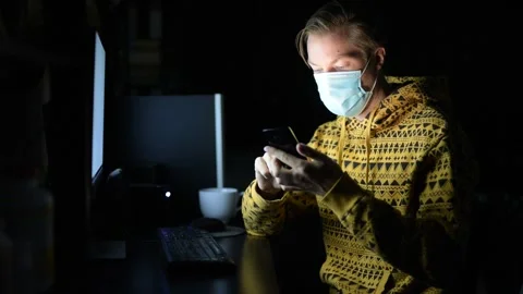 Young man with mask using phone while wo... | Stock Video | Pond5