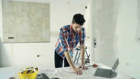 Young man reading blueprints by table an... | Stock Video | Pond5