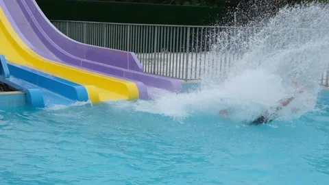 young man sliding on body slide with spl... | Stock Video | Pond5