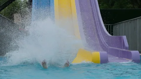 young man sliding on body slide with spl... | Stock Video | Pond5