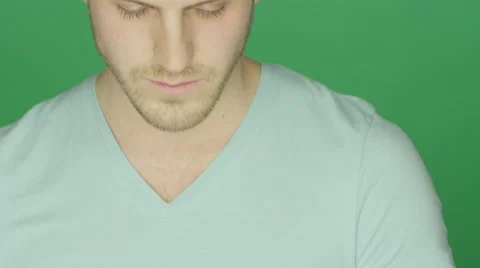 Young man smiles charmingly, on a green ... | Stock Video | Pond5