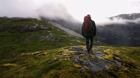 Young man standing at famous cliff edge ... | Stock Video | Pond5
