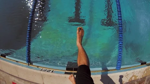 Young man stepping off the side of a swi... | Stock Video | Pond5