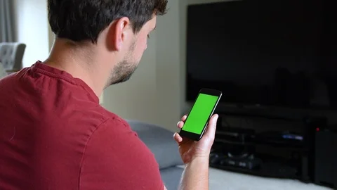 Young man tapping and scrolling on phone... | Stock Video | Pond5