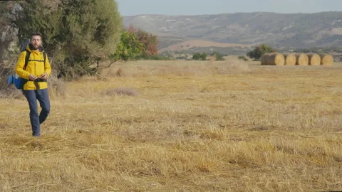 Young man traveler wandering in fields w... | Stock Video | Pond5