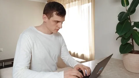 Young man is typing something on the lap... | Stock Video | Pond5