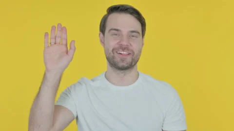 Young Man Waving Hand to Say Hello on Ye... | Stock Video | Pond5