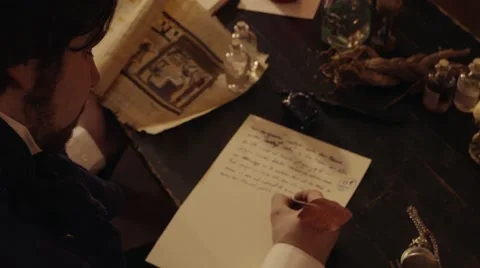 Young man writing letter in mystical off... | Stock Video | Pond5