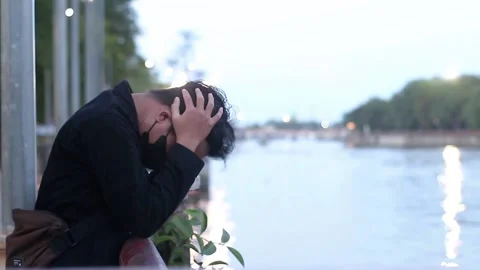 Young men wear masks alone sad at park | Stock Video | Pond5