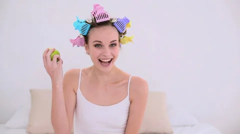 Young model in hair rollers holding red ... | Stock Video | Pond5