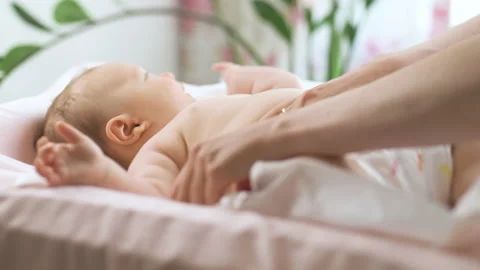 Young mother changing her baby's diaper | Stock Video | Pond5