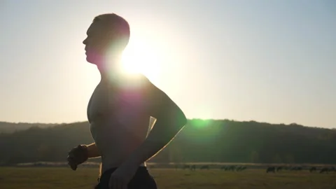 Young muscular man running through field... | Stock Video | Pond5