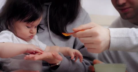 Young parents give healthy food to baby,... | Stock Video | Pond5