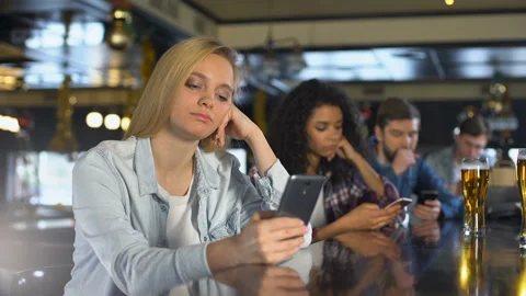 Young people bored in bar, using phones ... | Stock Video | Pond5