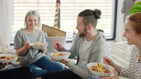 Young people moving in new home, eating.... | Stock Video | Pond5