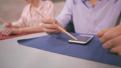 Young people sit at the table in front o... | Stock Video | Pond5