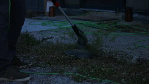 Young Person Weed Whacking Front Of Comm... | Stock Video | Pond5