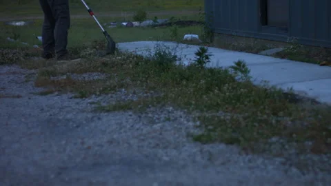 Young Person Weed Whacking Front Of Comm... | Stock Video | Pond5